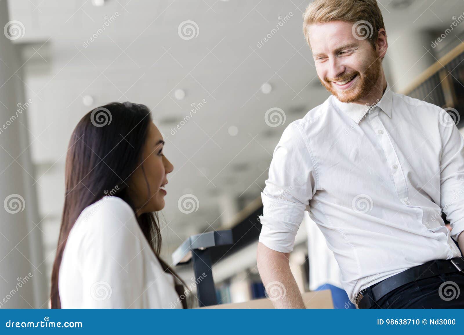A Group of Academics Studying in the Library and Conversing Stock Photo ...