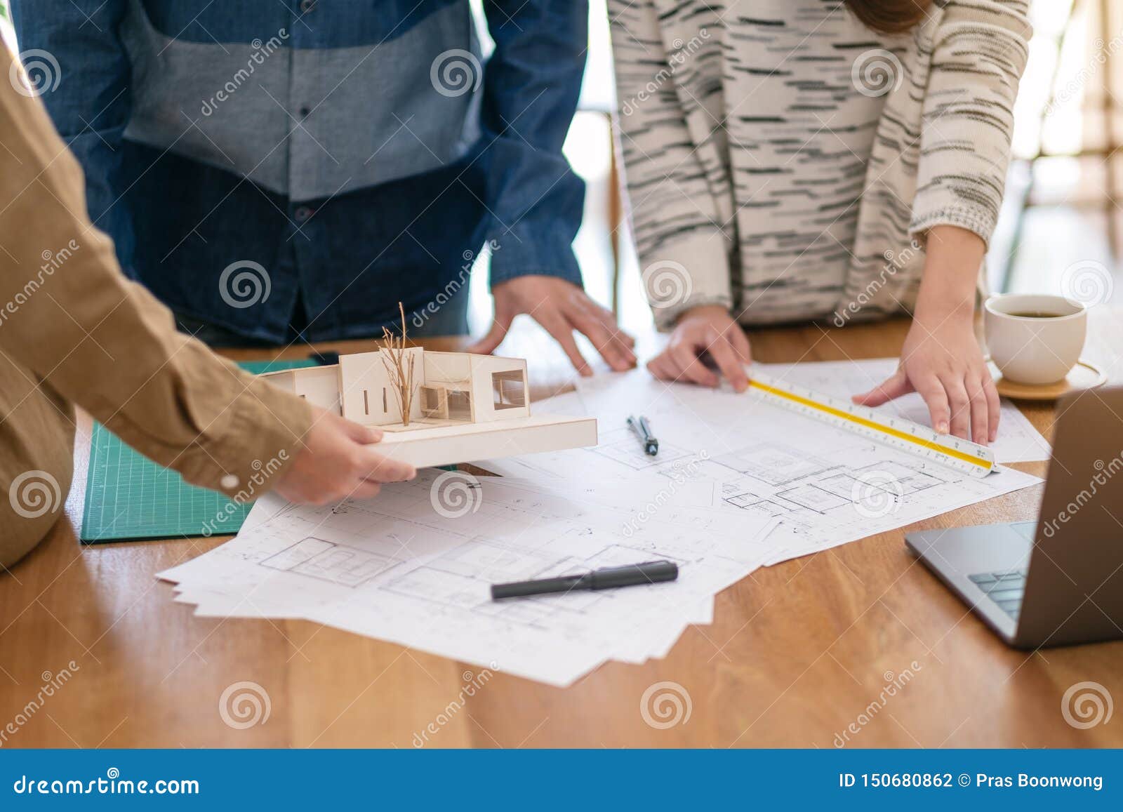 An Architect Working and Measuring Scale of a Mass Model on Table in ...