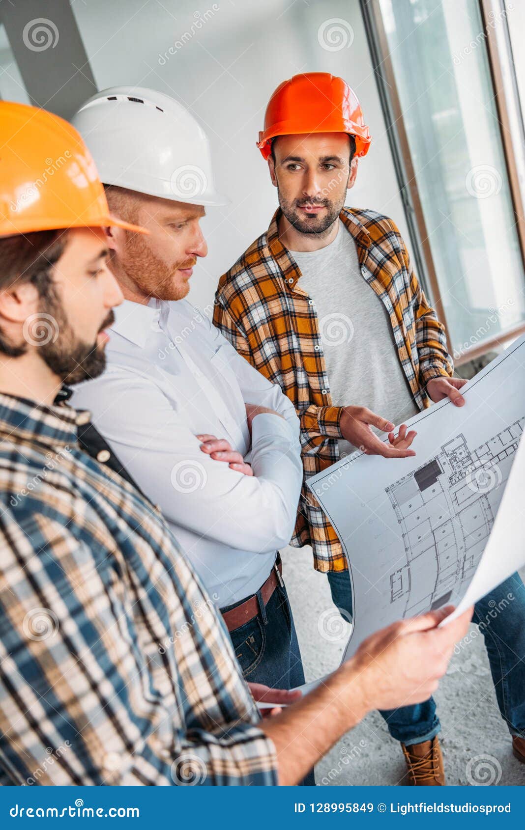 Group of Architects with Blueprint Having Conversation Inside of Stock ...