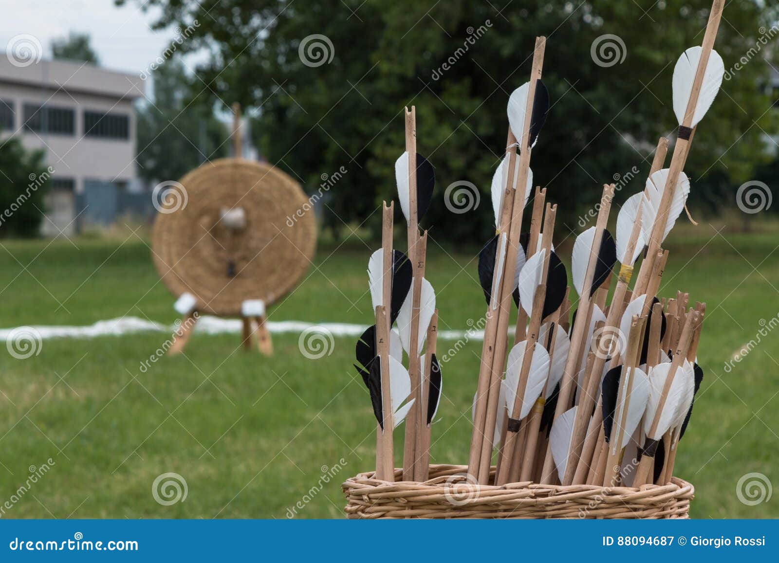 Group of Arrows Inside Wicker Basket and Straw Archery Target in Stock ...