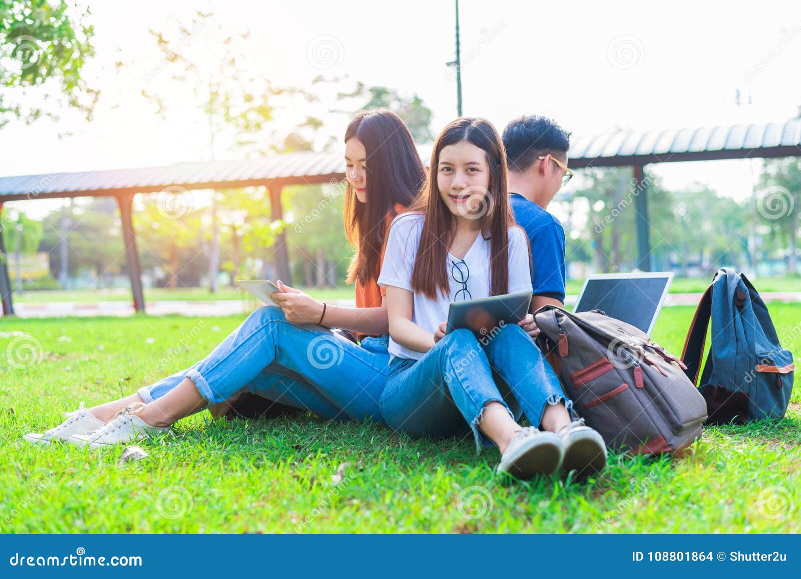 Group of Asian College Student Using Tablet and Laptop on Grass Stock ...