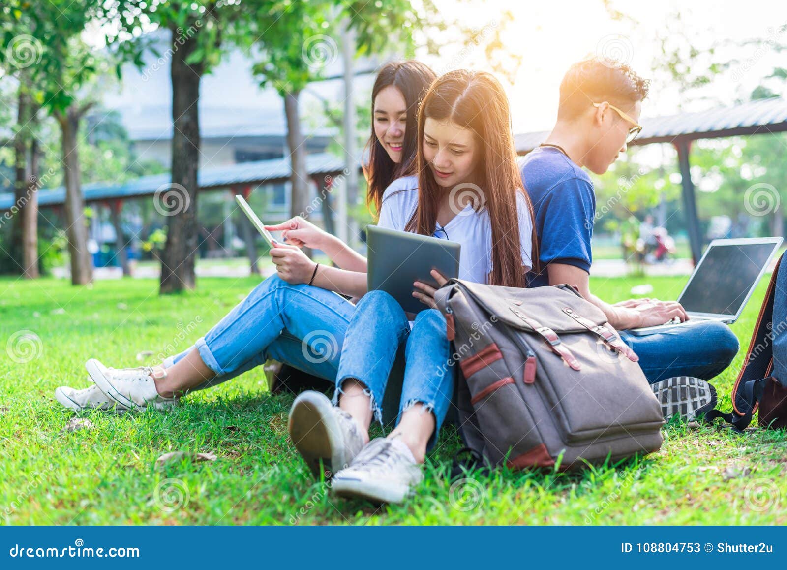 Group of Asian College Student Using Tablet and Laptop on Grass Stock ...