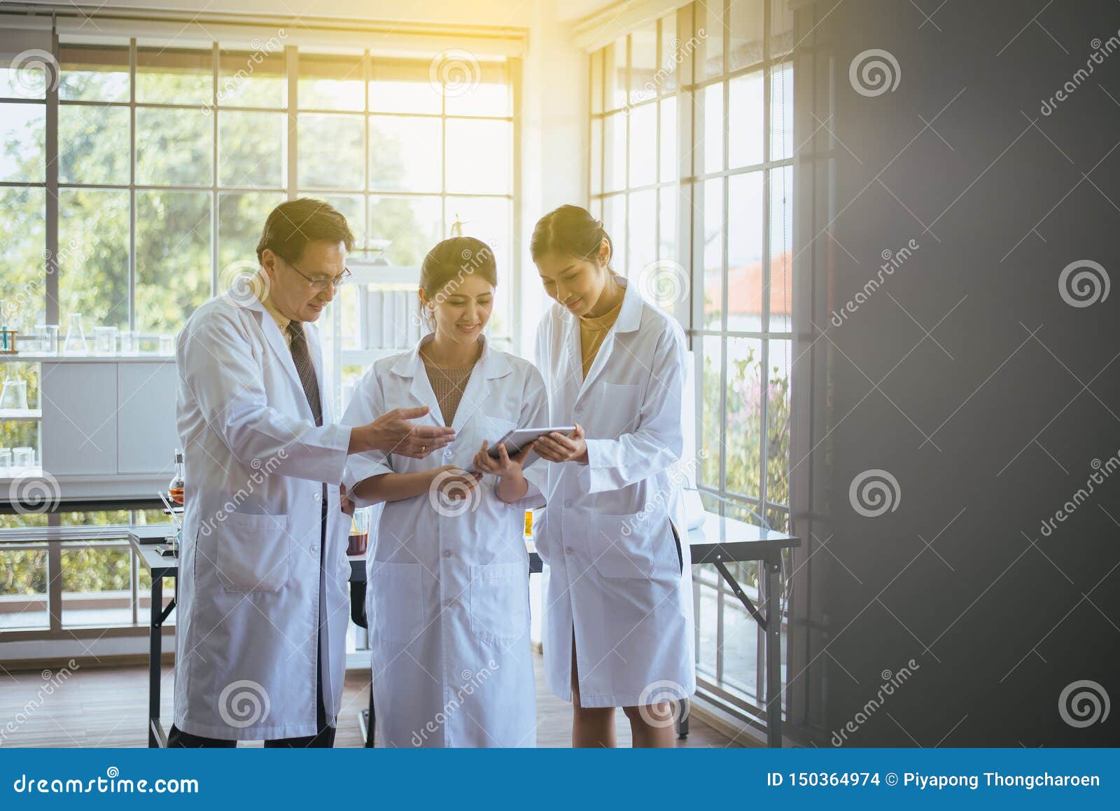 Group of Asian Scientist Using Tablet Computer and Analyzing Data ...