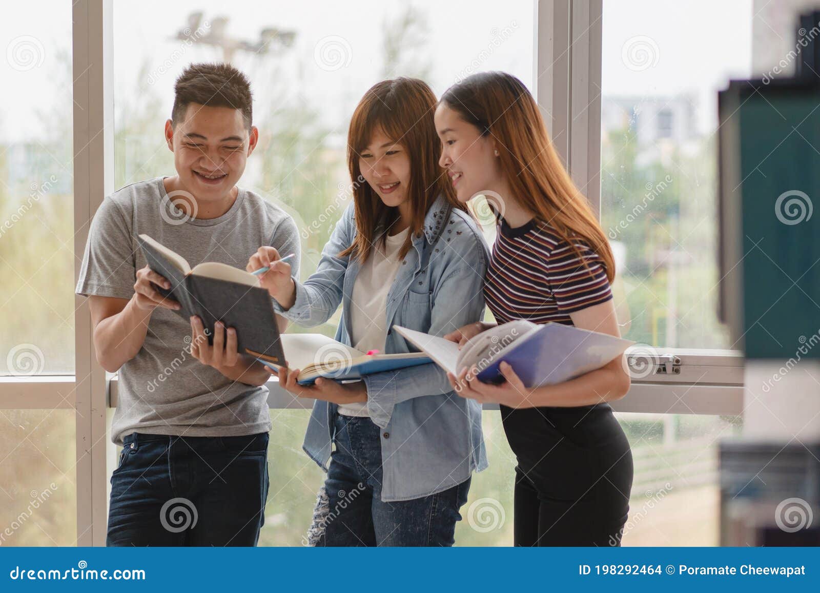 Group of Asian Students Researching Data for Homework Assignment in ...