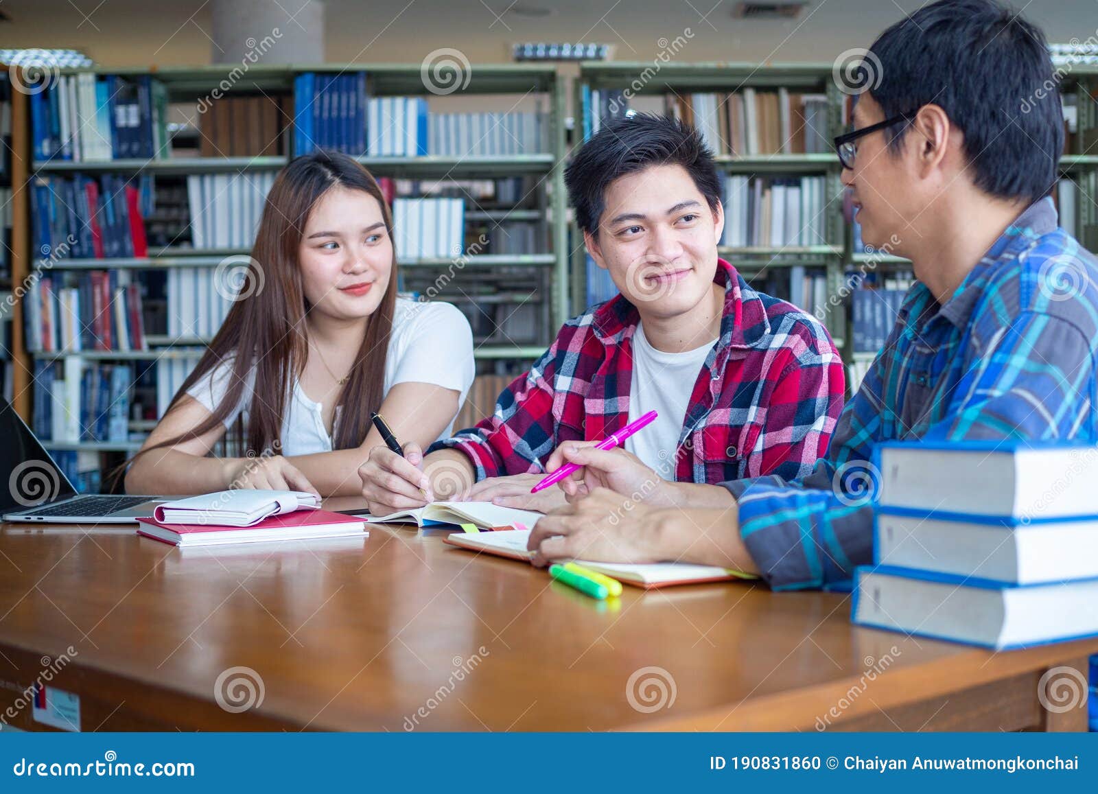 A Group of Asian Students Sitting and Discussing Read Books Together ...