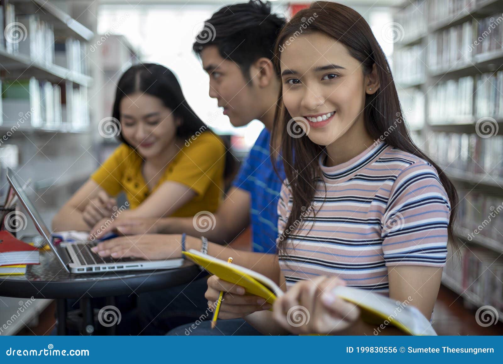 Group Asian Students Smile and Reading a Book and Using the Laptop for ...