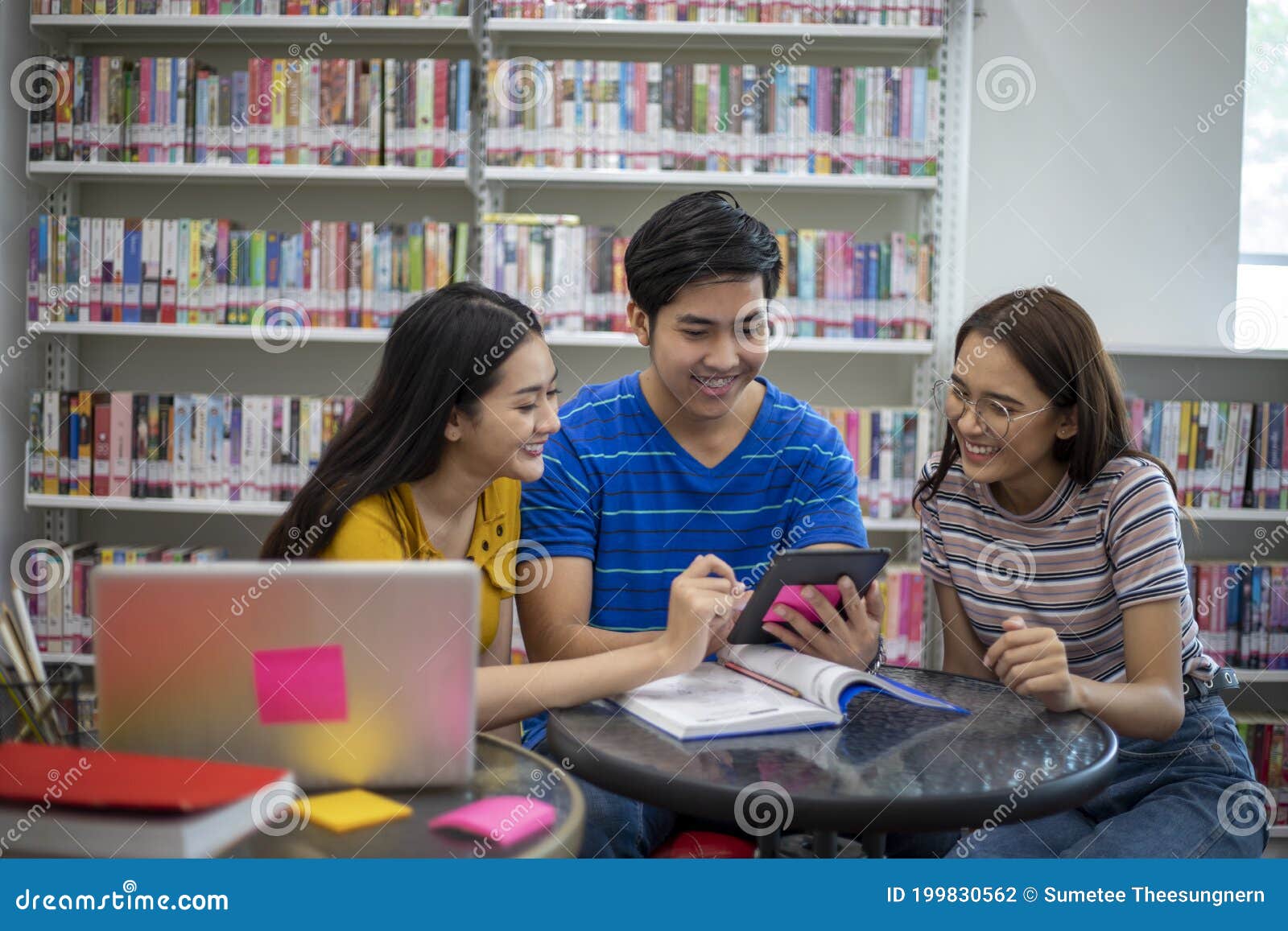 Group Asian Students Smile and Reading a Book and Using the Laptop for ...
