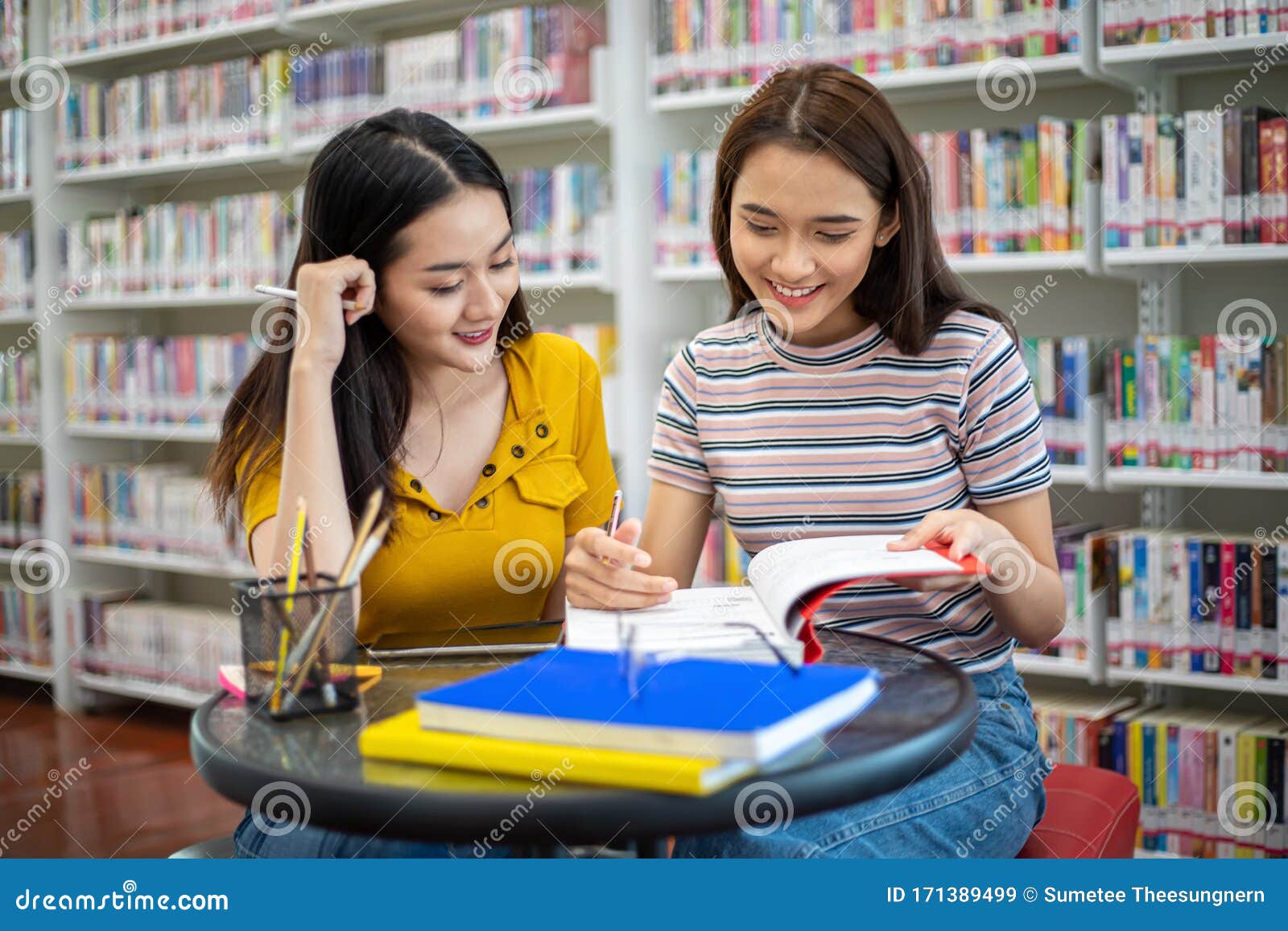 Group Asian Students Smile and Reading Book and Using Notebook for ...