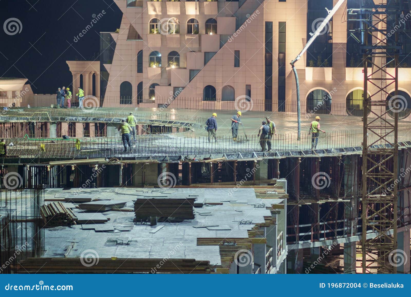 Group of Building Workers Working on Illuminated Construction Site at ...