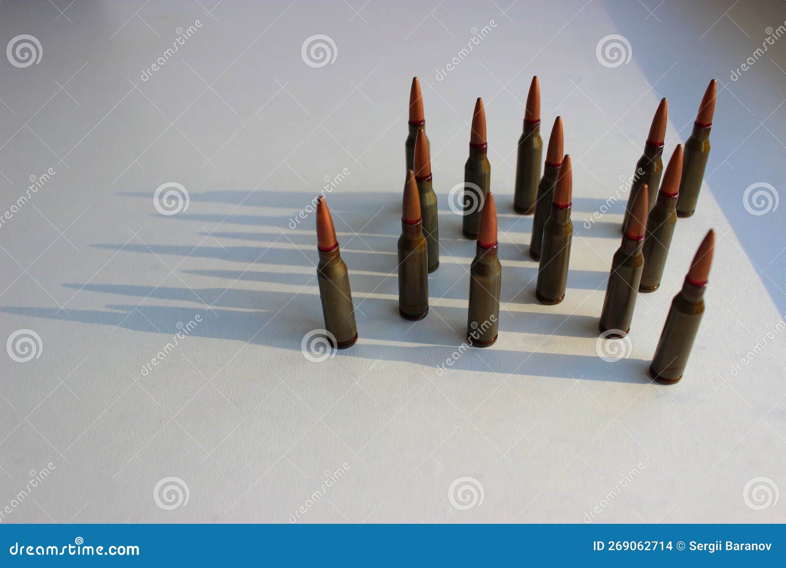 A Group of Bullets Stands on a White Surface and Casts a Shadow Stock ...