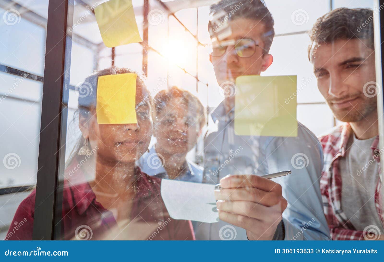 A Group of Business People Behind a Glass Wall in the Office Sticking ...