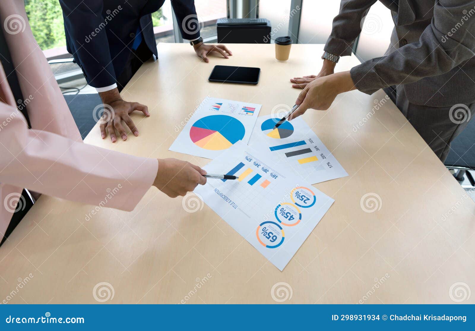 A Group of Business Professional are Huddled Together Around a Table ...