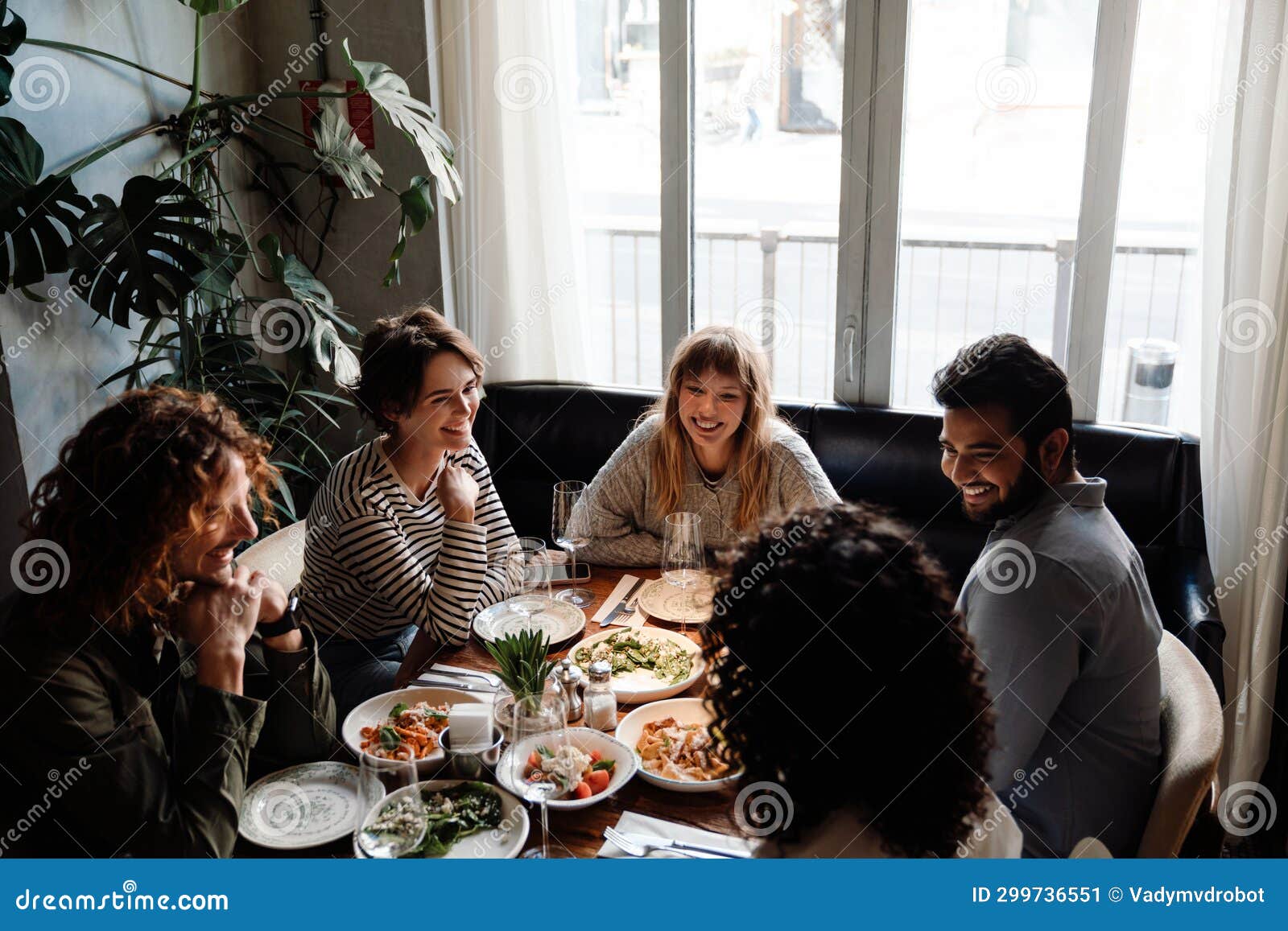 Group of Cheerful Friends Talking while Dining in Restaurant Stock ...