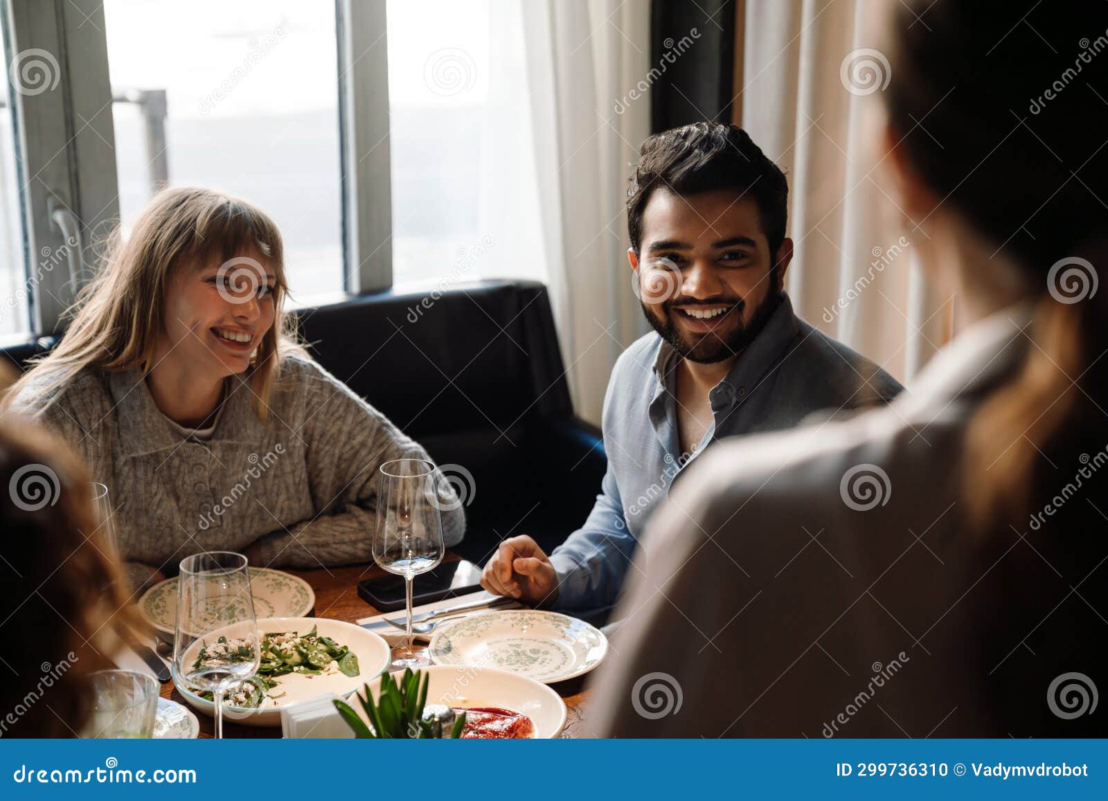 Group of Cheerful Friends Talking while Dining in Restaurant Stock ...