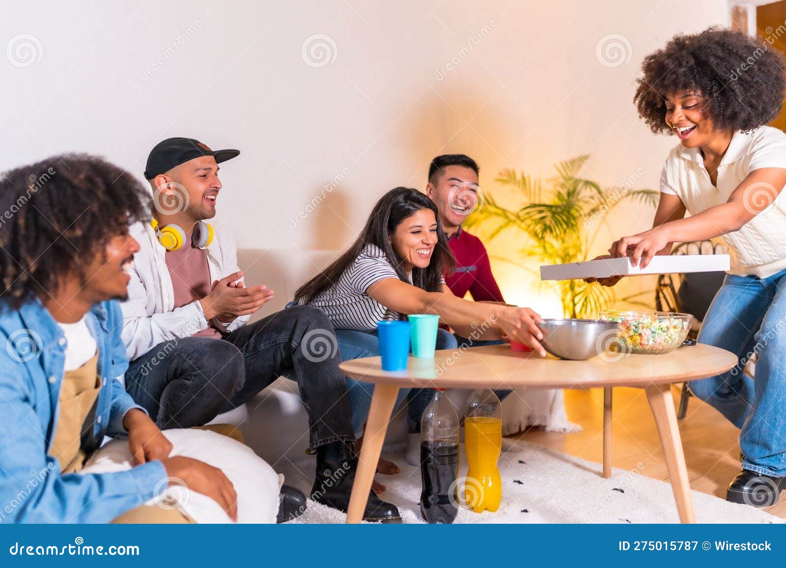 Group of Cheerful Multiethnic Friends on a Sofa Eating Pizza at a Home ... Group of Cheerful Multiethnic Friends on a Sofa Eating Pizza at a Home ...