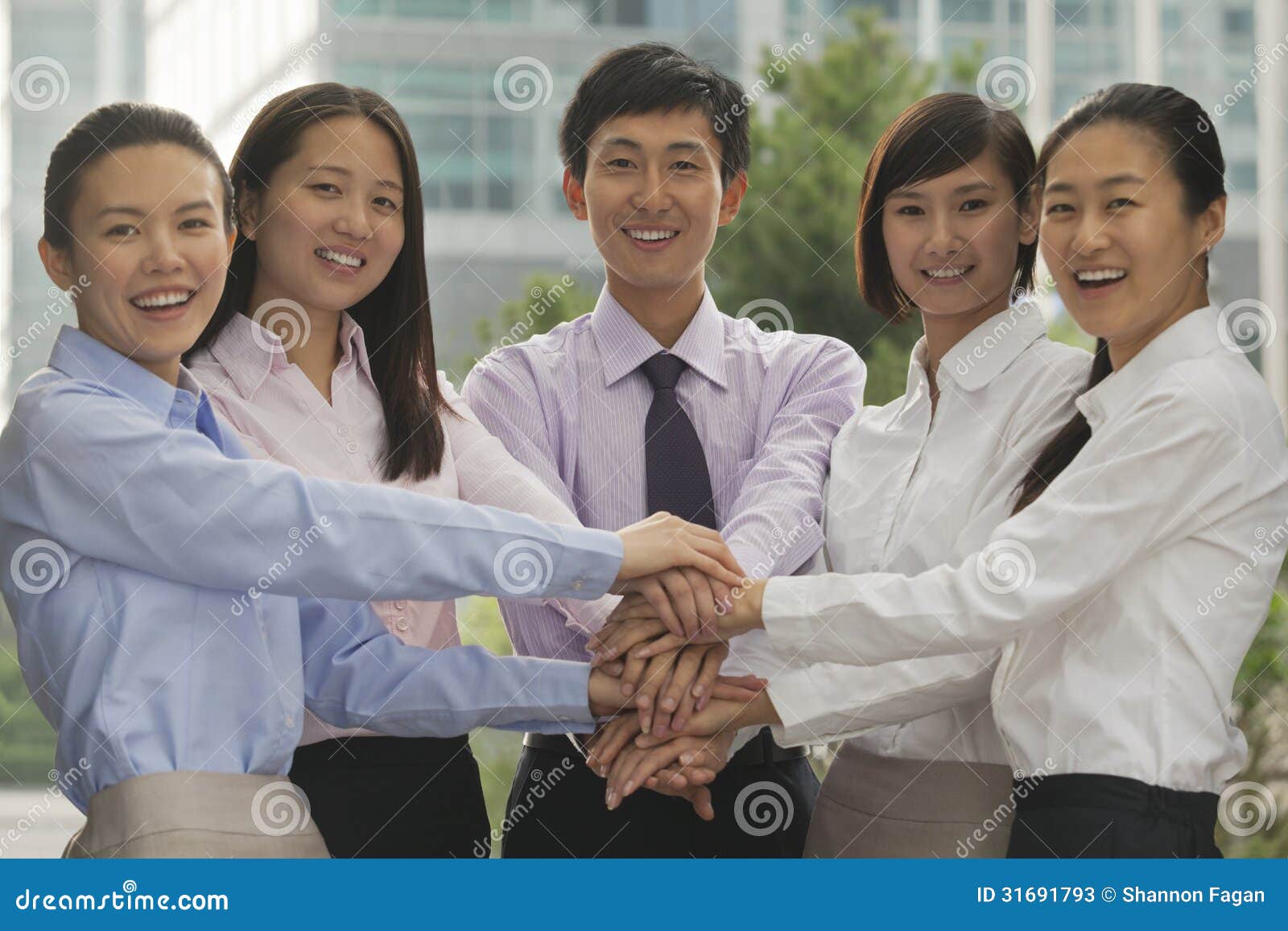 Group of Cheerful Young Business People with Hands on Top of Each Other ...