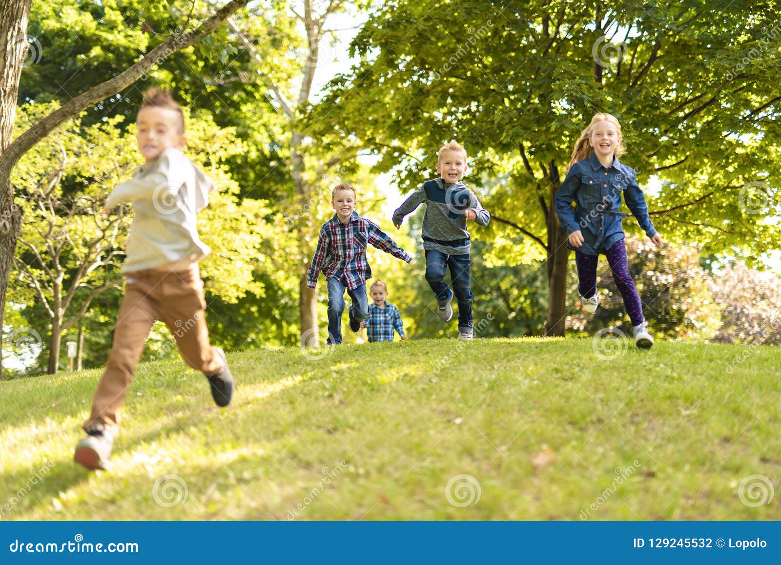 A Group of Children in Spring Field Having Fun Stock Photo - Image of ...