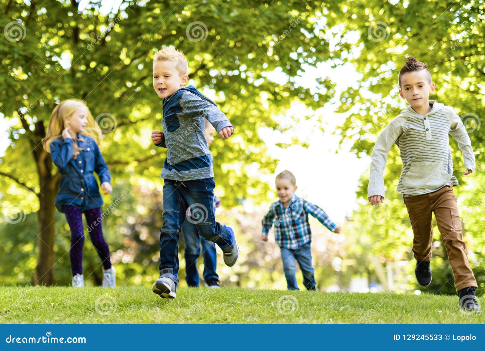 A Group of Children in Spring Field Having Fun Stock Image - Image of ...