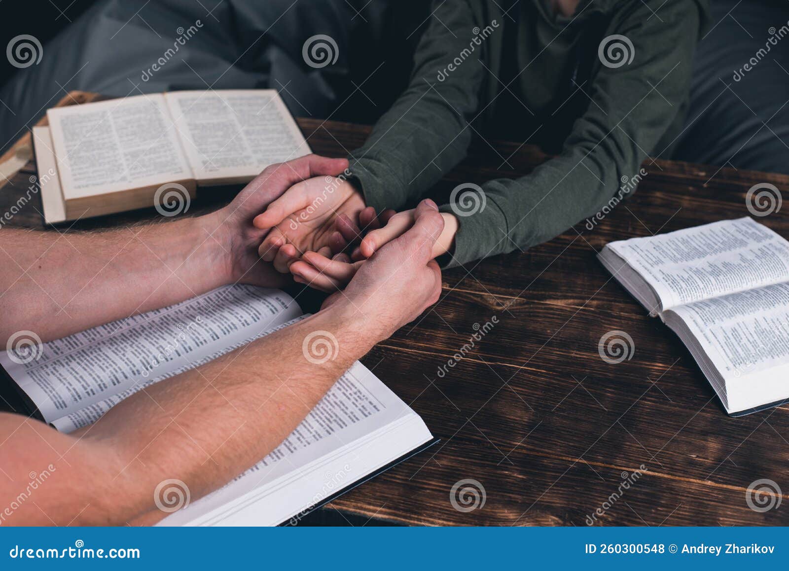 A Group of Christians Pray Holding Hands. on the Table. the Holy Bible is Open. Praying Stock ...