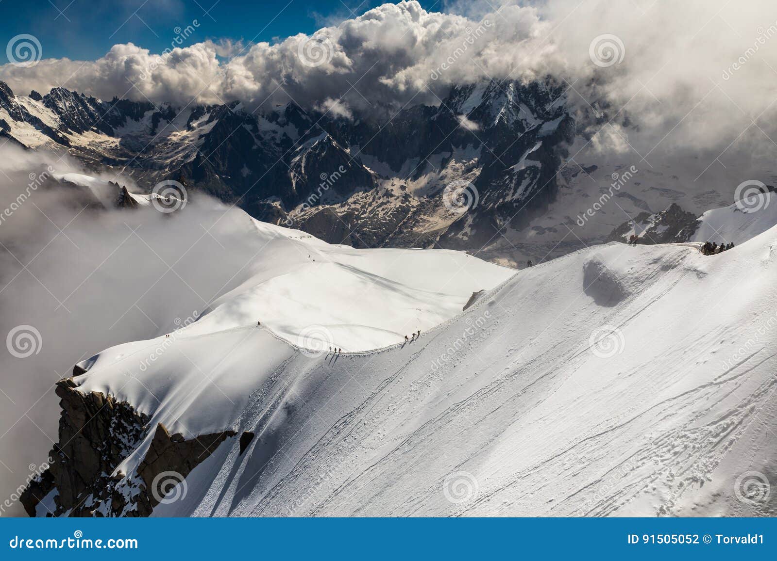 A Group of Climbers Walking on a Mountain Ridge Above the Cliff Stock ...