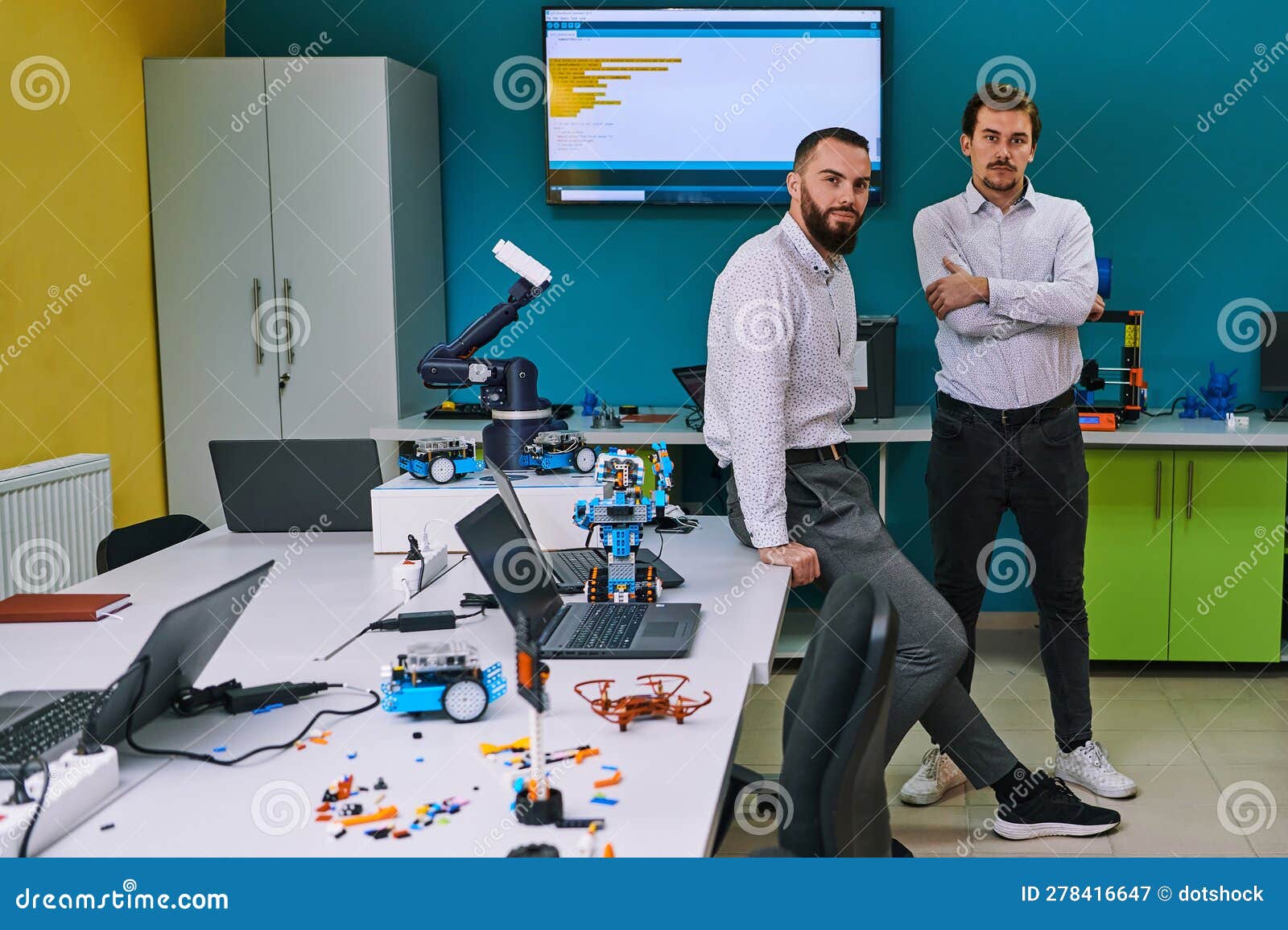 A Group of Colleagues Collaborate in a Lab while Testing a 3D Printer ...