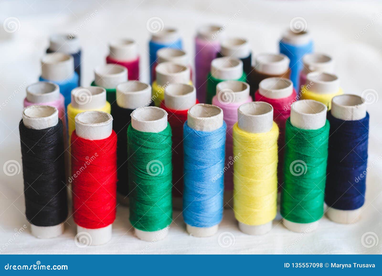 Group of Colored Thread Spools on White Cotton Cloth Stock Photo ...