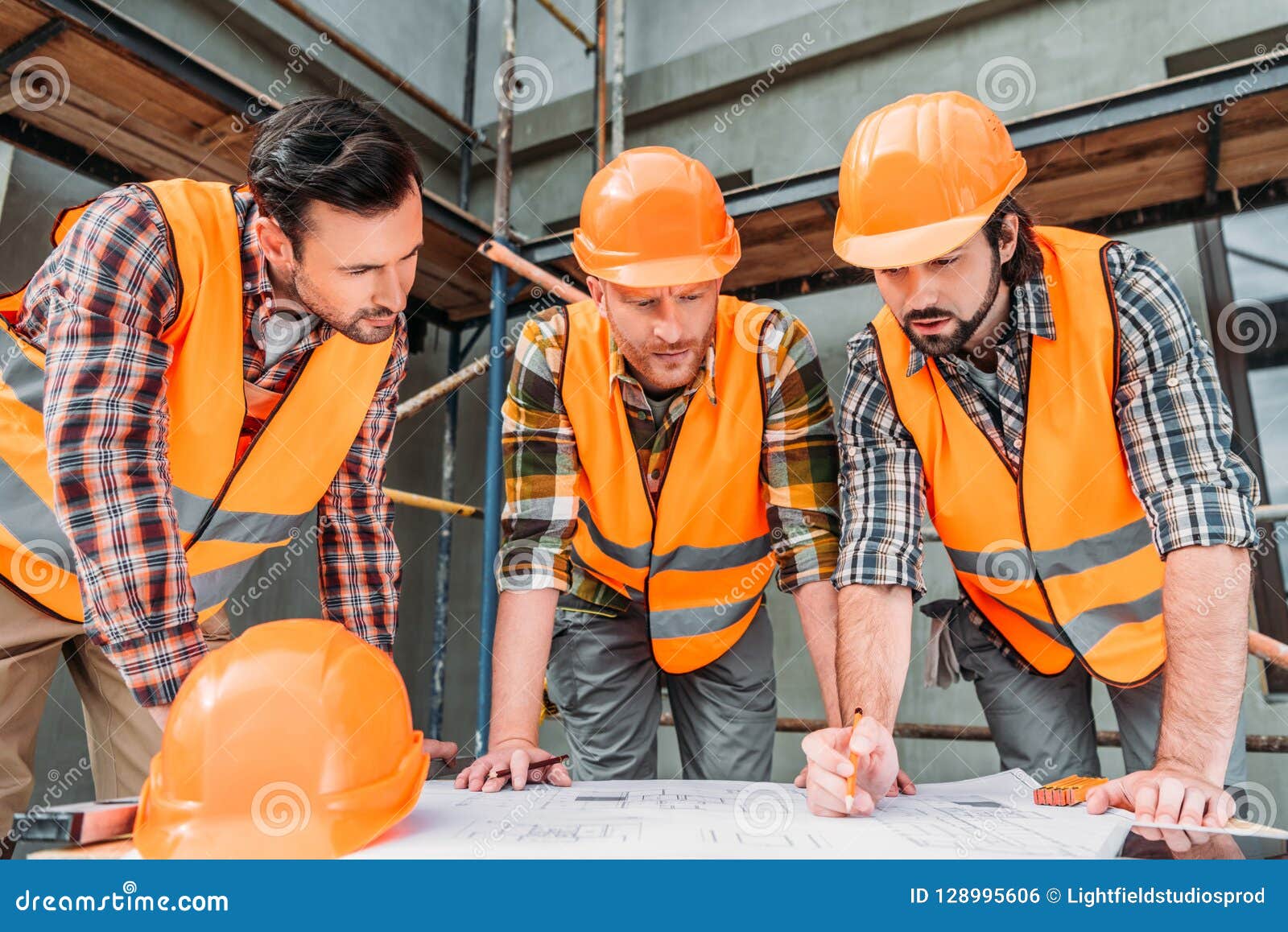 Group of Confident Builders Looking at Building Plan Stock Photo ...