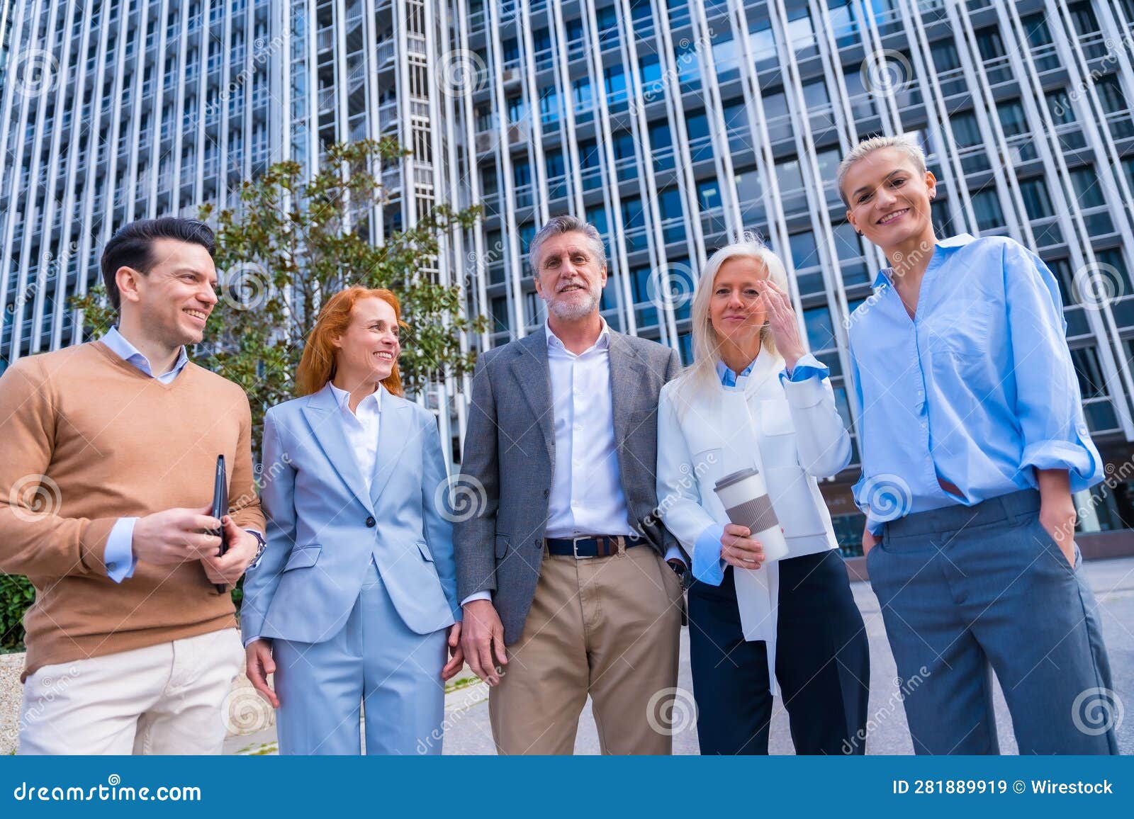 Group of Confident Business Professionals Posing in Front of a Modern ...