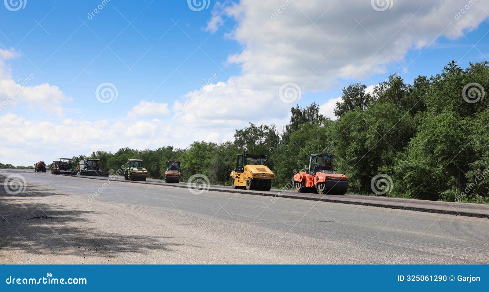 A Group of Construction Vehicles are Lined Up on a Road Stock Photo ...