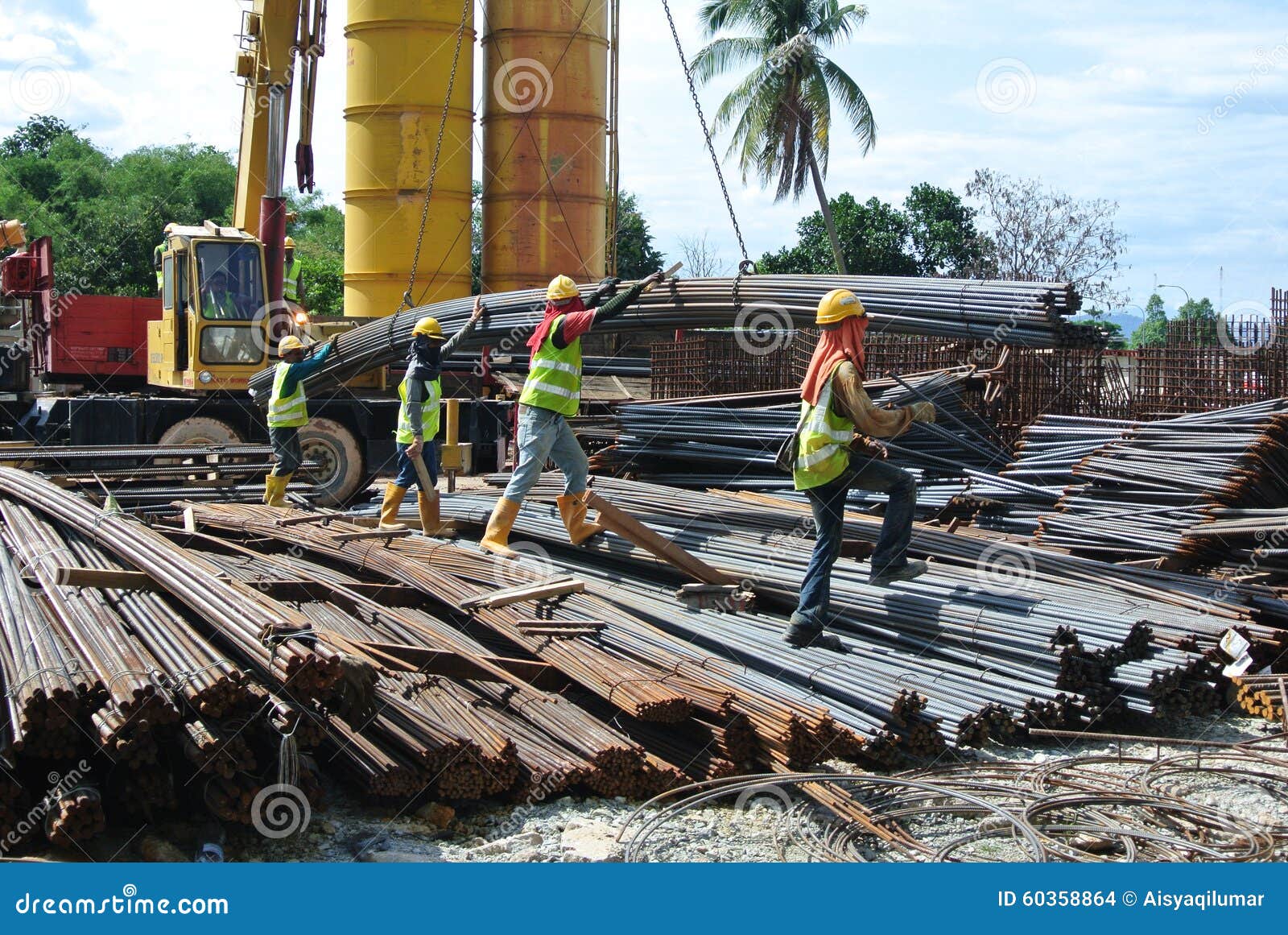 Group of Construction Workers Lifting Bundle of Reinforcement Bar Using ...