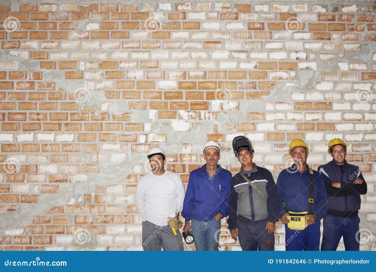 Group of Laughing Construction Workers by Brick Wall Stock Photo ...