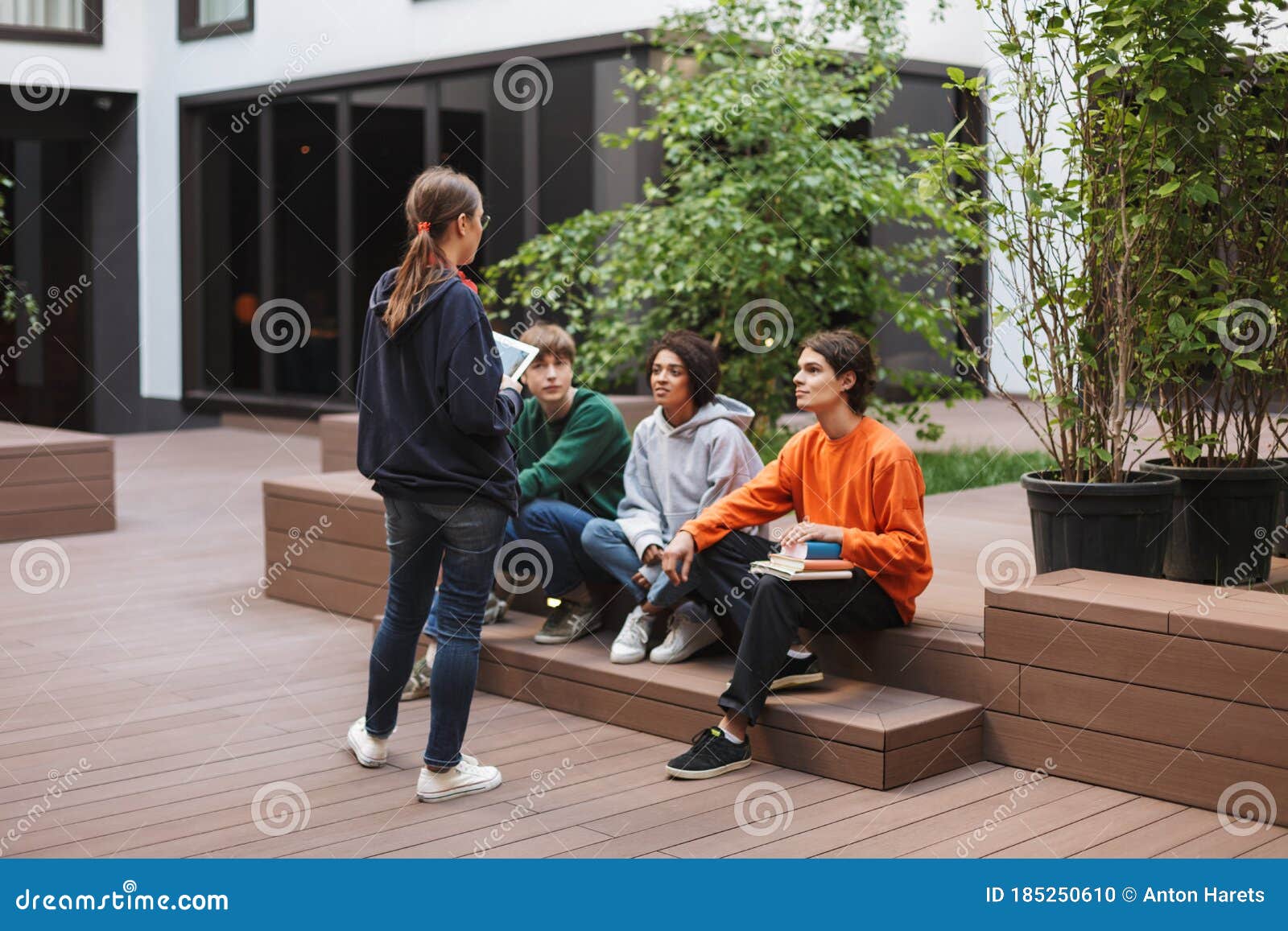 Group of Cool Students Sitting and Preparing for Lesson while Studying ...
