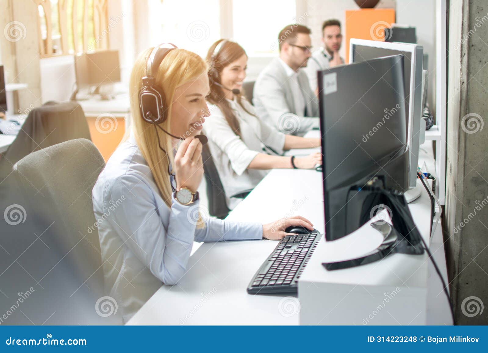 Group of Customer Service Operators Working in Row in Call Center ...