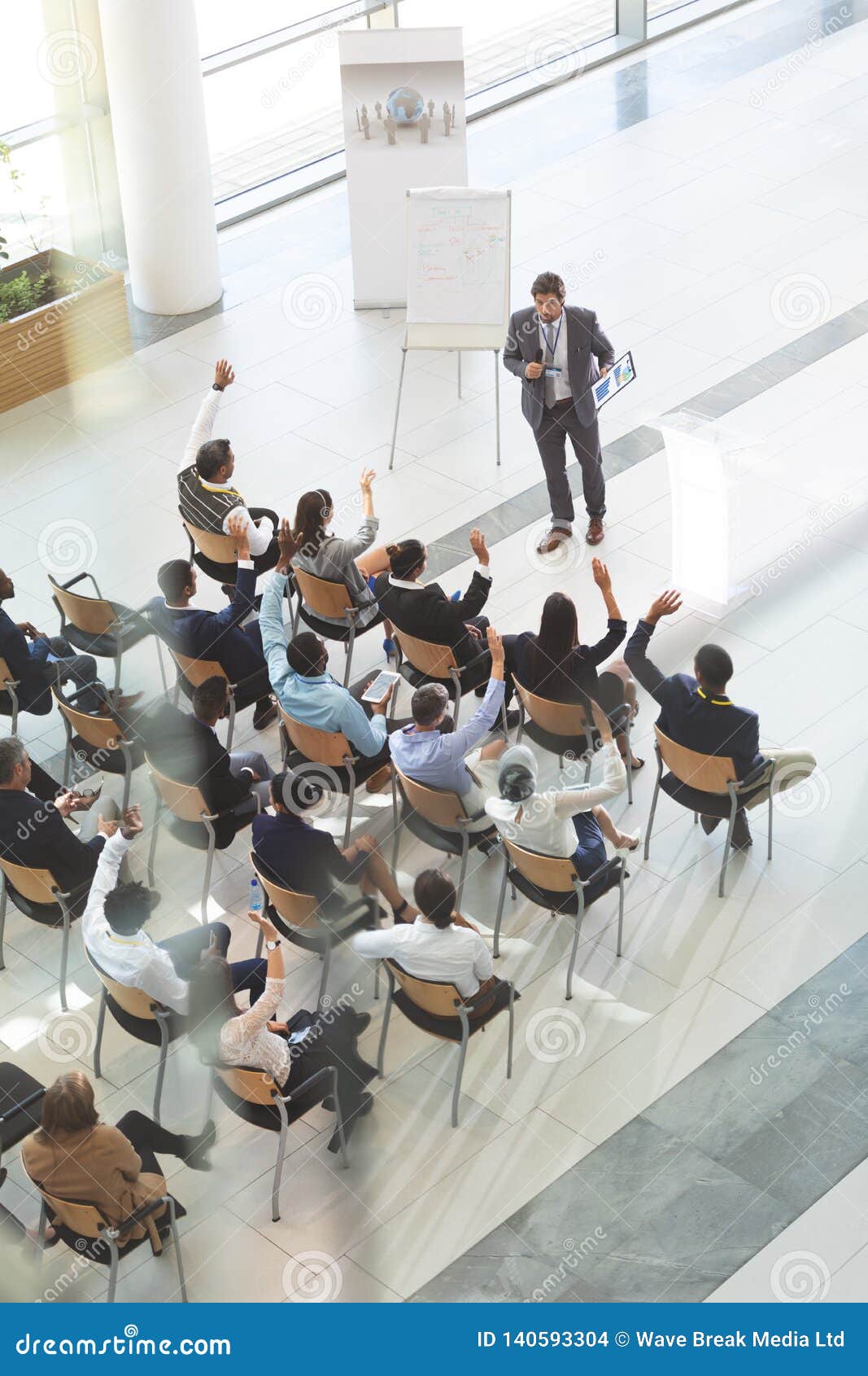 Group Of Diverse Business People Raising Their Hands To Ask Questions
