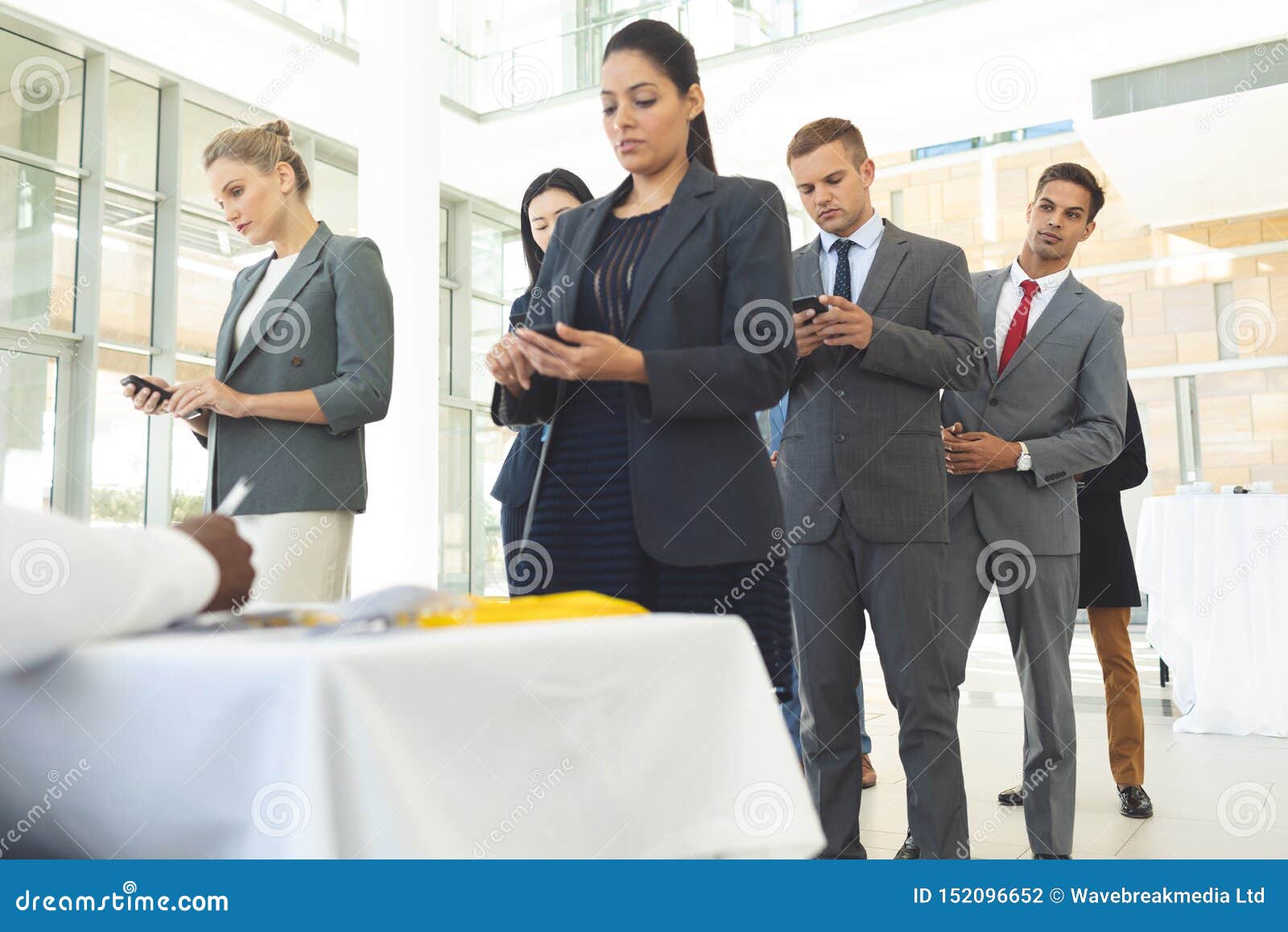 Group of Diverse Business People Texting on Mobile Phone while Queuing ...