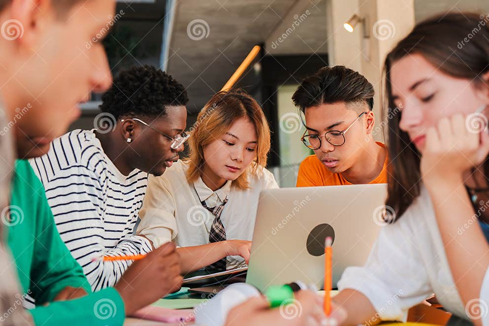 A Group of Diverse Students is Actively Collaborating on a Laptop in a ...