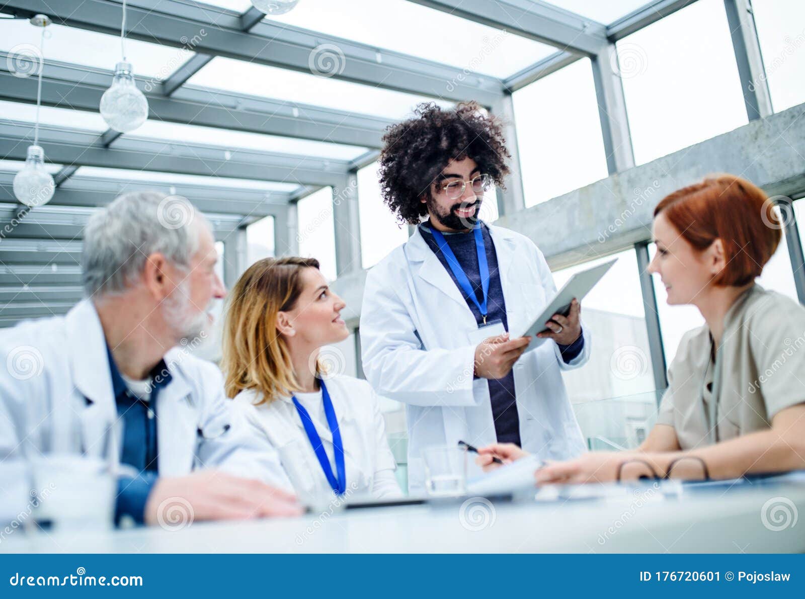 Group of Doctors with Tablet on Conference, Medical Team Discussing ...