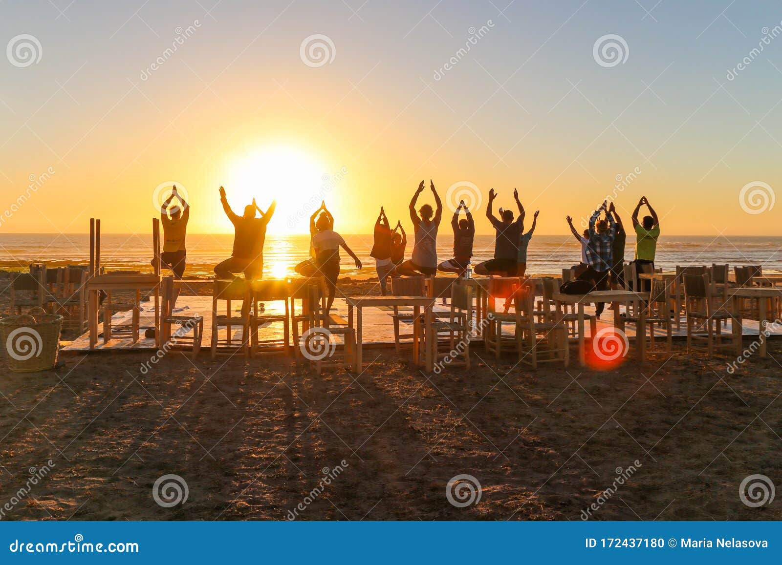 Group Doing Yoga Exercises the Beach at Sunset Stock Photo - Image of ...