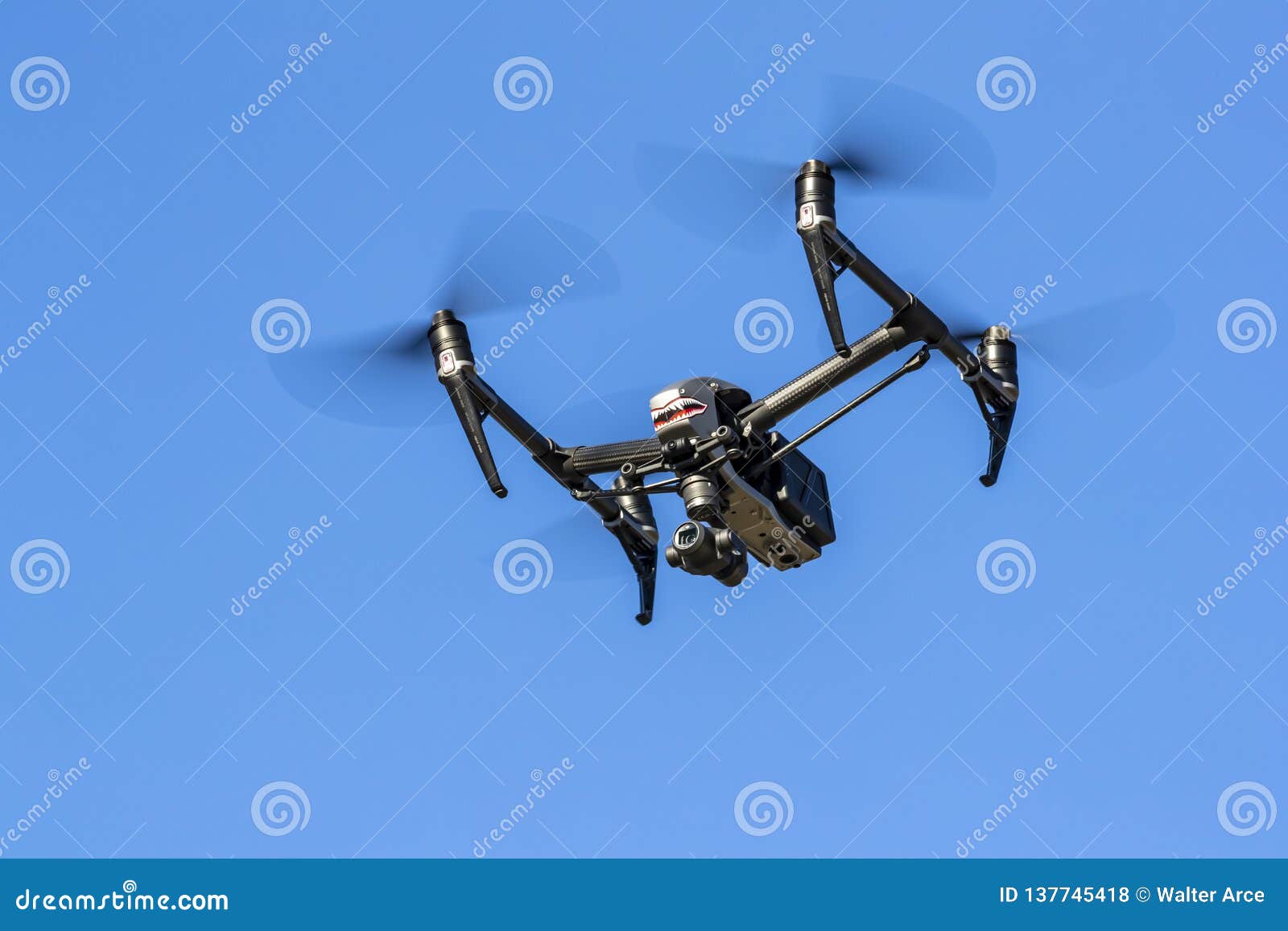 A Group of Drones Fly Together through the Air Against a Blue Sky Stock ...