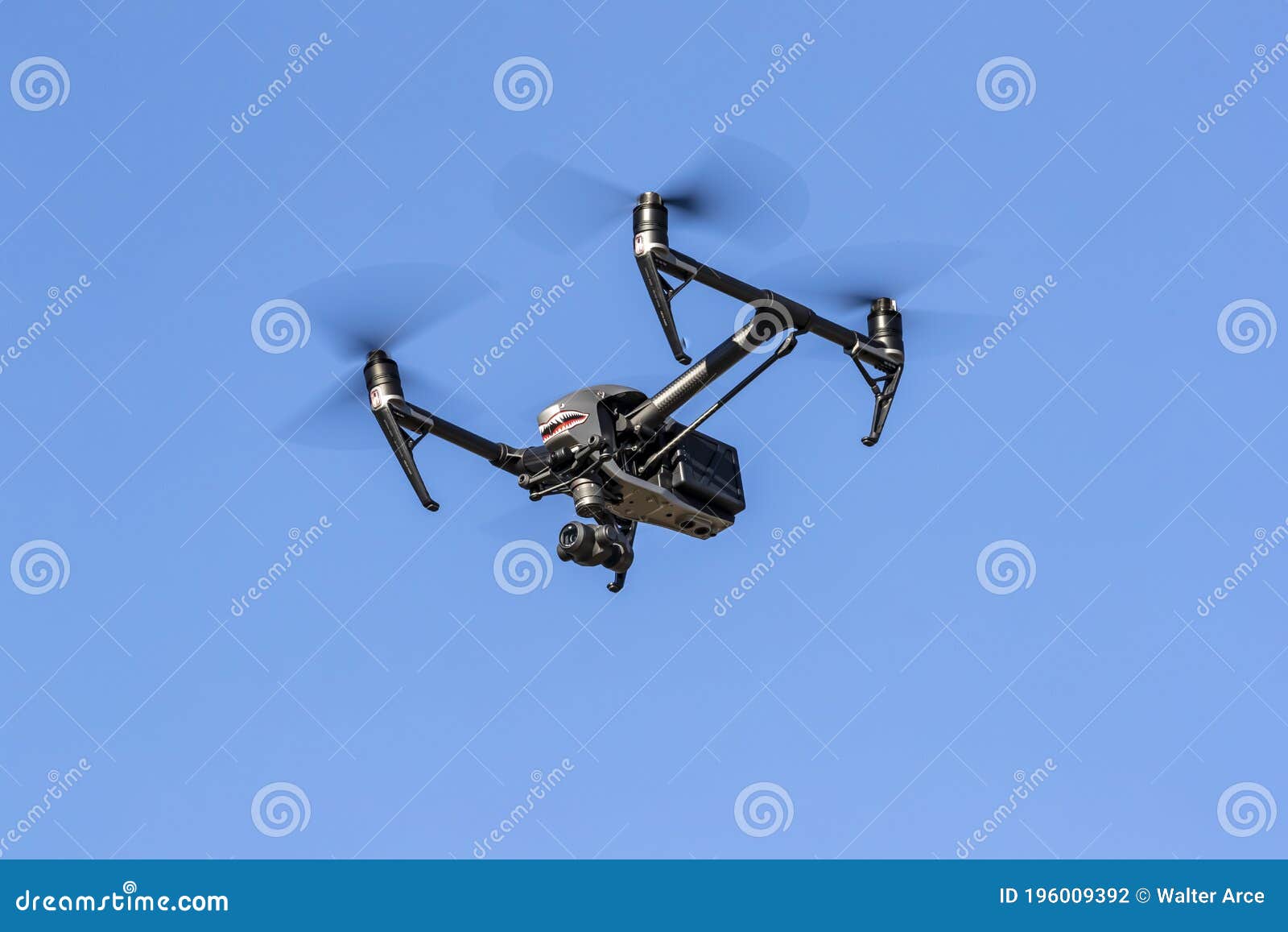 A Group of Drones Fly Together through the Air Against a Blue Sky Stock ...