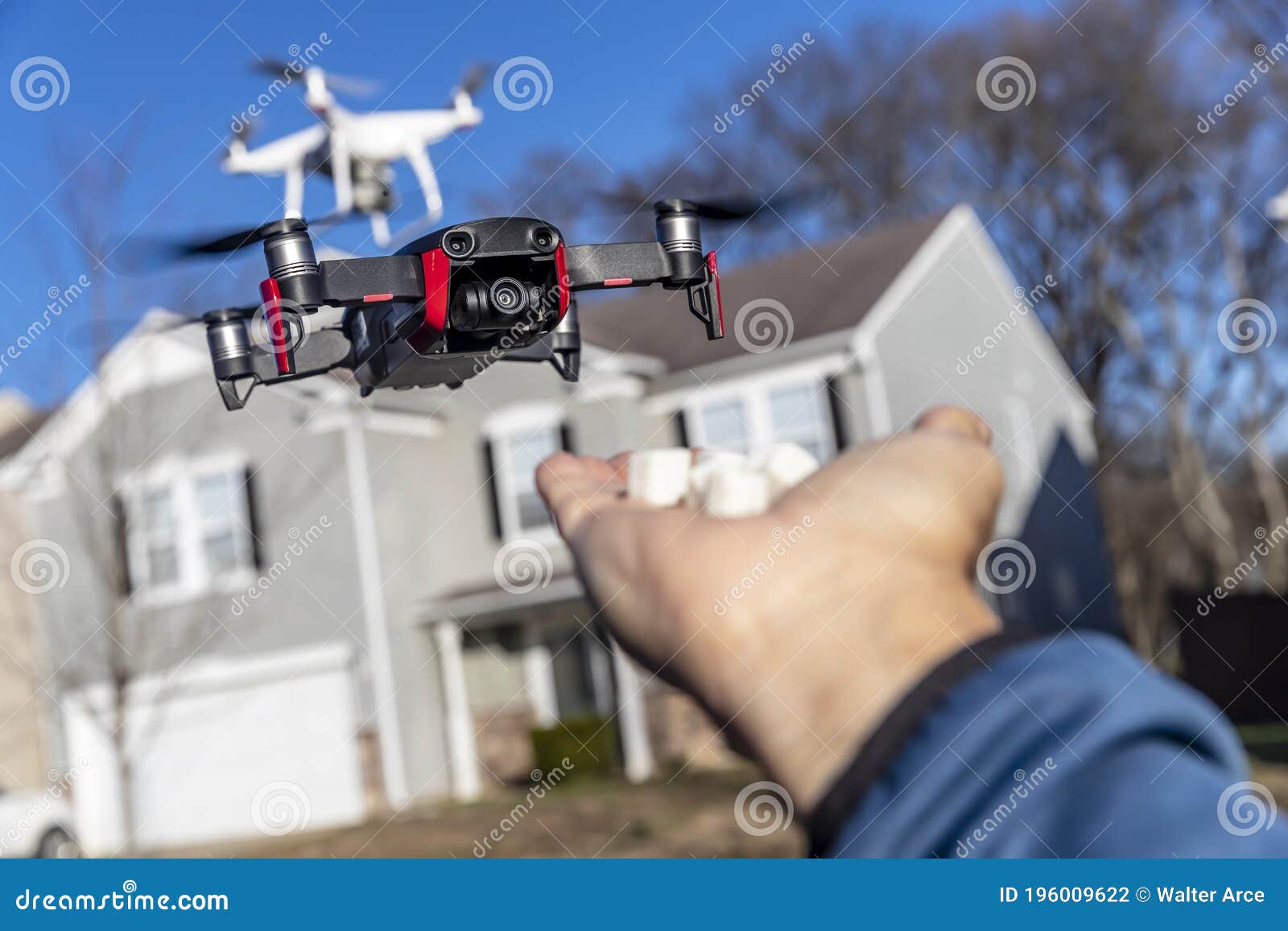 A Group of Drones Fly Together through the Air Against a Blue Sky Stock ...