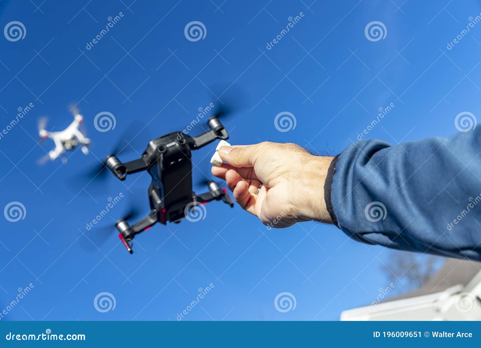 A Group of Drones Fly Together through the Air Against a Blue Sky Stock ...