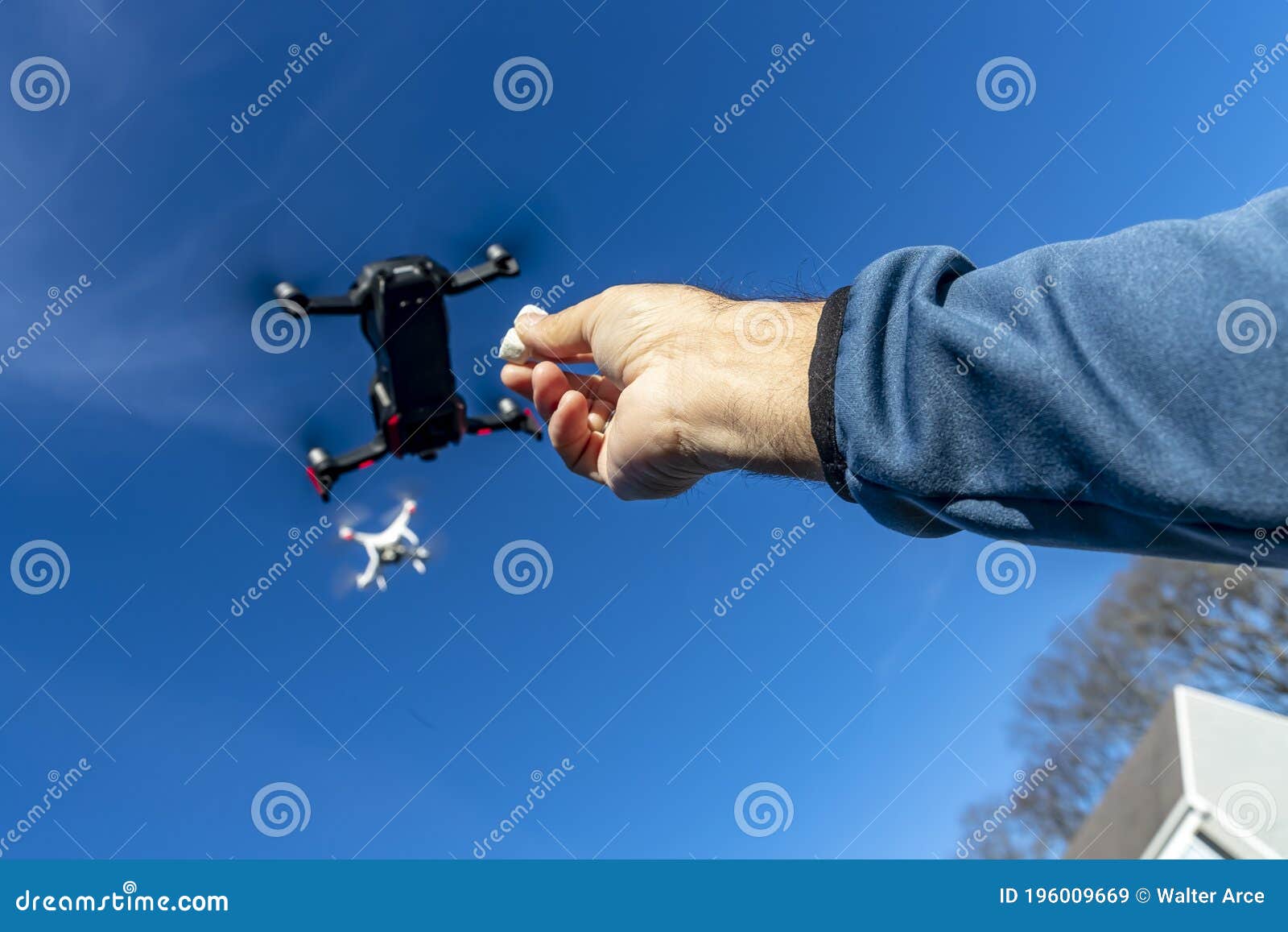 A Group of Drones Fly Together through the Air Against a Blue Sky Stock ...