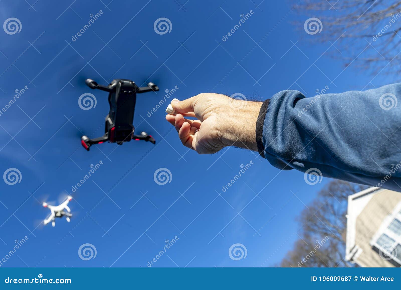 A Group of Drones Fly Together through the Air Against a Blue Sky Stock ...