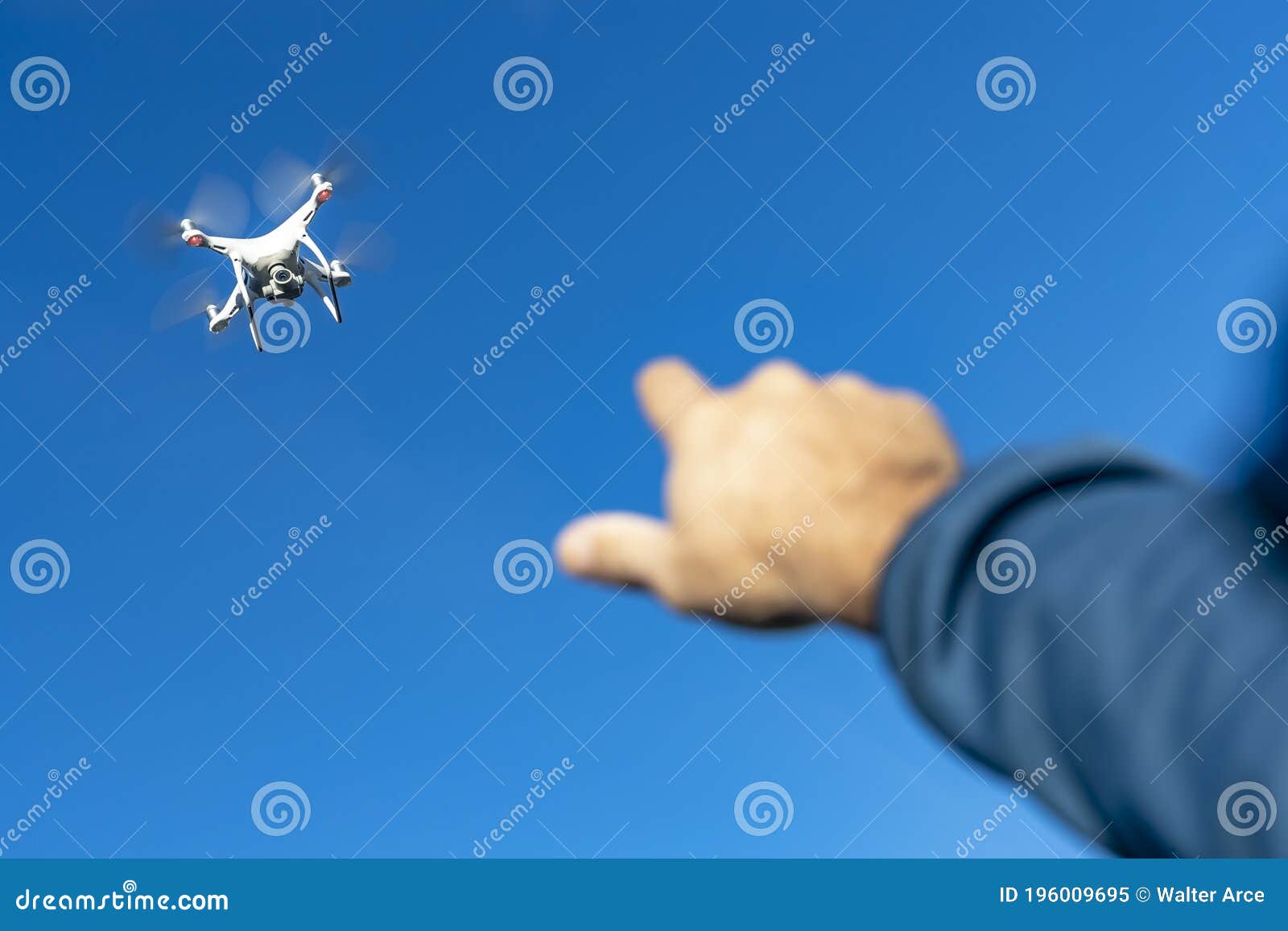 A Group of Drones Fly Together through the Air Against a Blue Sky Stock ...