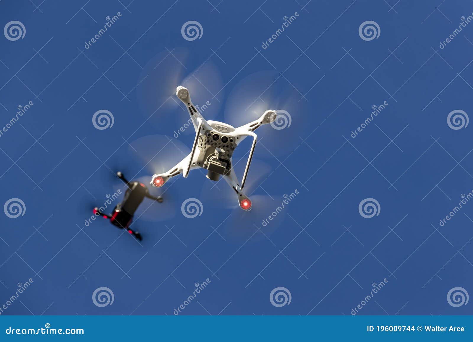 A Group of Drones Fly Together through the Air Against a Blue Sky Stock ...