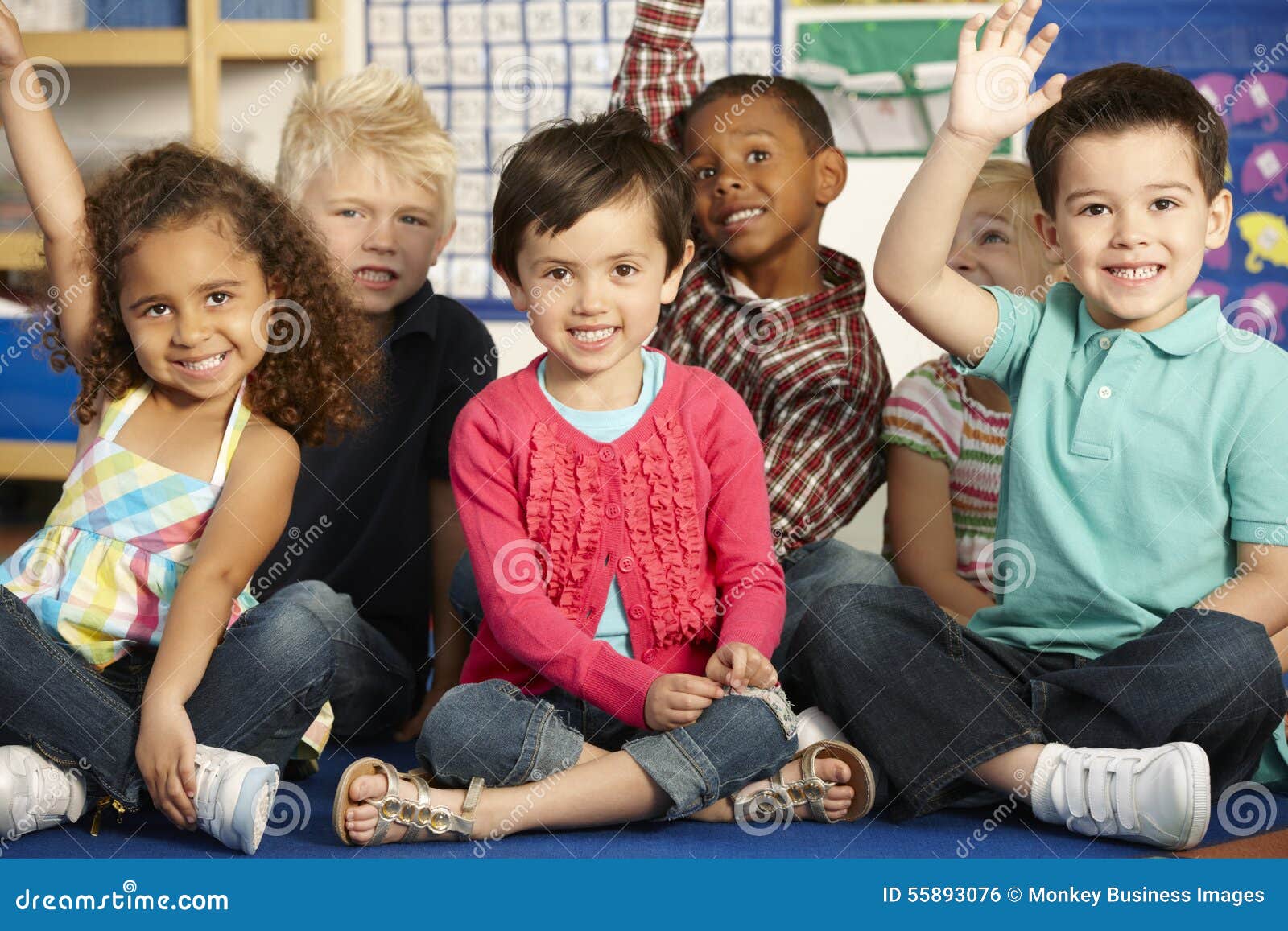 Group of Elementary Age Schoolchildren Answering Question in Class ...