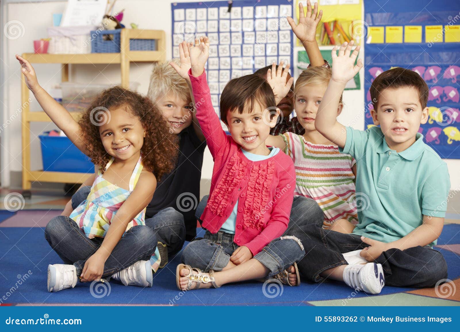 Group of Elementary Age Schoolchildren Answering Question in Class ...