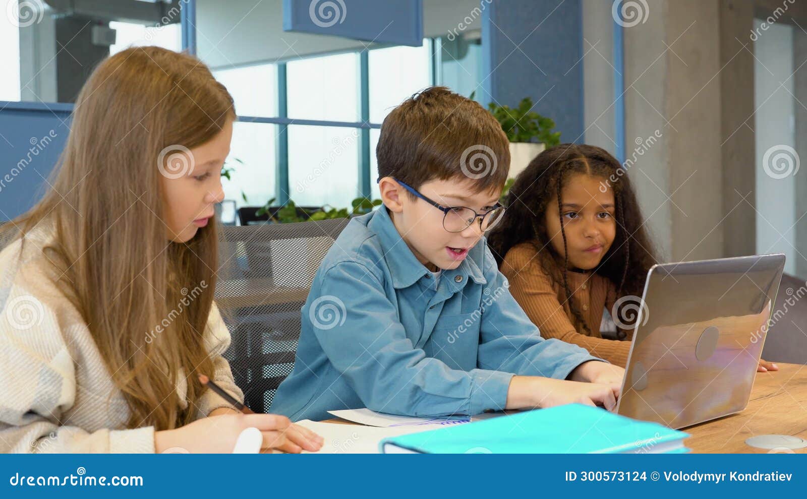 Group of Elementary School Children Working Together on Laptop in Class ...