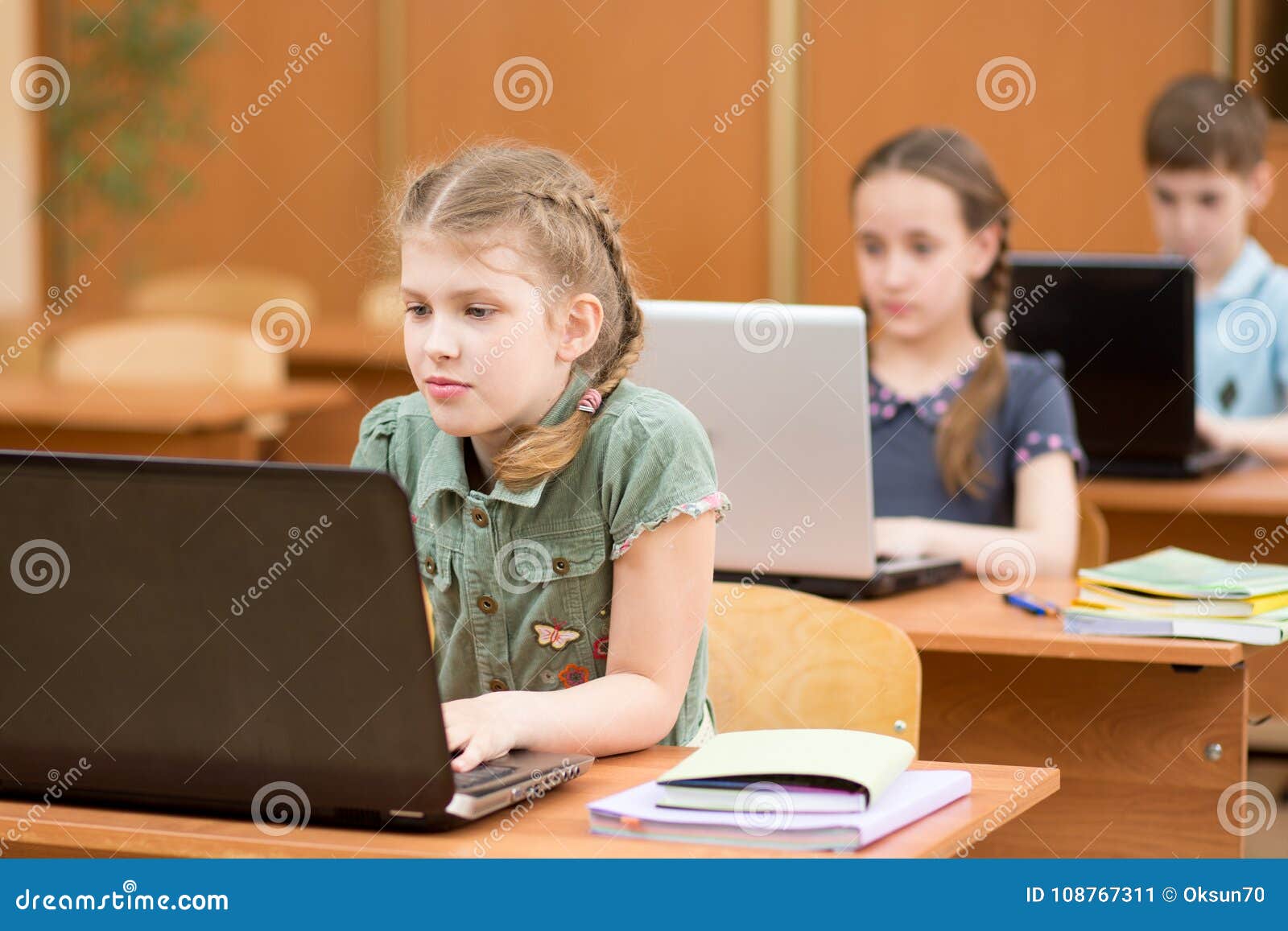Group Of Elementary School Pupils Sitting On Floor Listening To Female ...